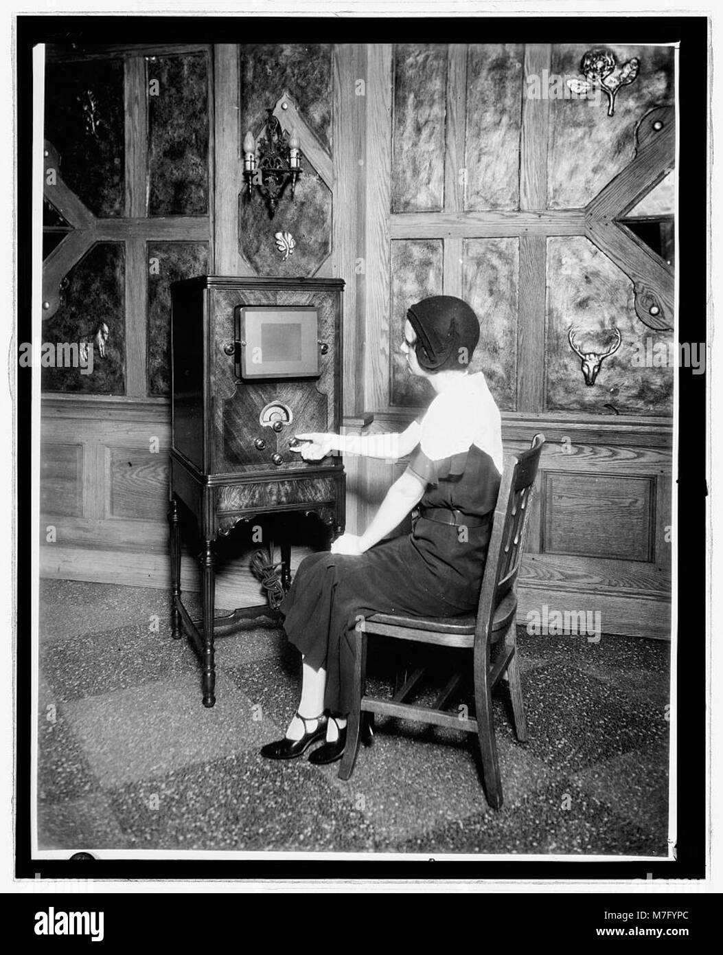 This photograph depicts a woman operating a radio, capturing a moment ...