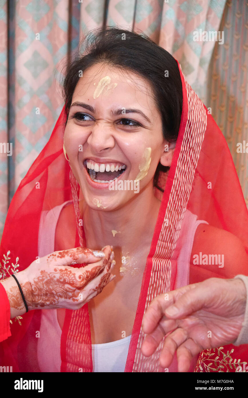 Indian pre wedding ceremony blessing bride to be with turmeric paste ...