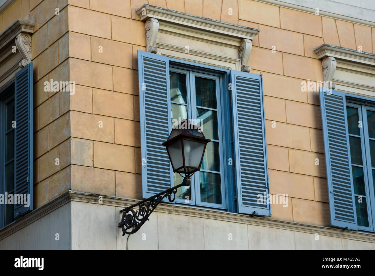 Colorful windows and facade with a street lamp. Rome, Italy Stock Photo ...