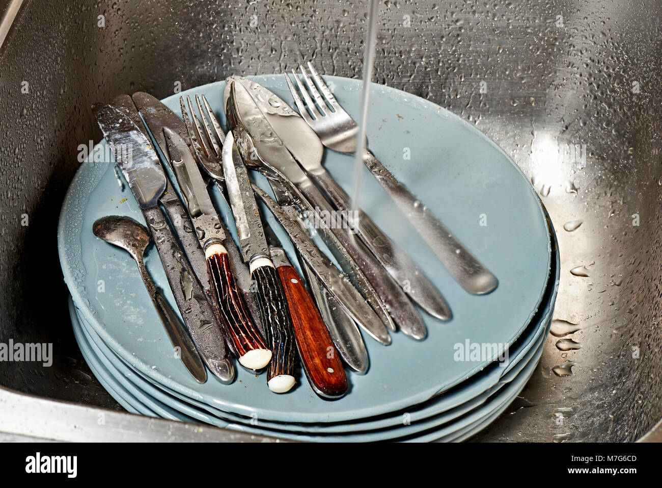 Dirty plates and cutlery in kitchen sink before washing Stock Photo - Alamy