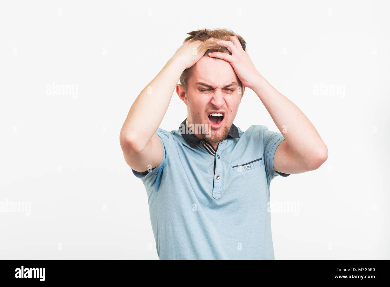 Stressed Young Man Clutching the Head in white background Stock Photo ...