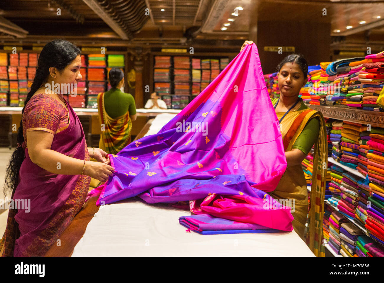 women folding material at pothys store in trivandrum Stock Photo - Alamy