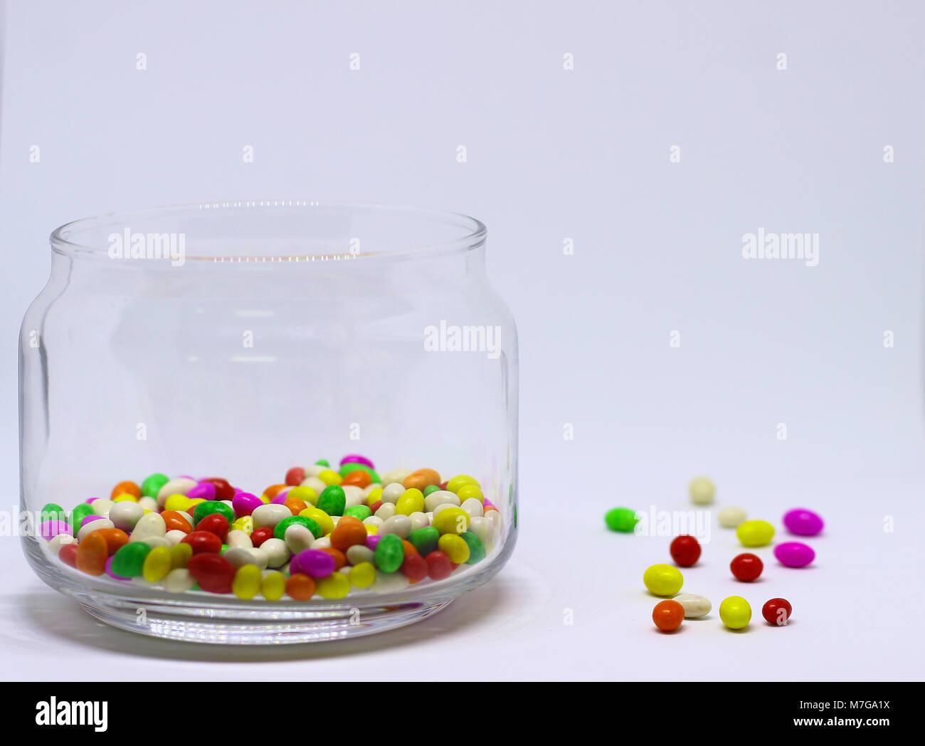 Multiple colored Sugar Candy In Glass Container in White Background ...