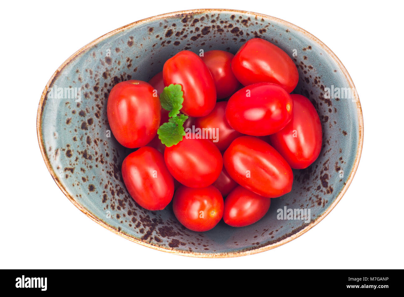 Small red tomatoes of oval shape in blue plate Stock Photo - Alamy