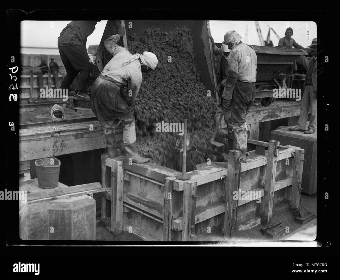 This image shows the construction of the Haifa harbor, with workers ...