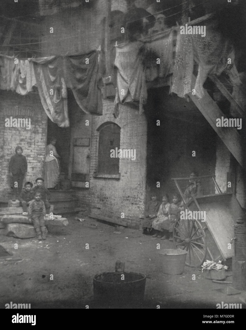A photograph by Jacob A. Riis showing a crowded tenement yard ...