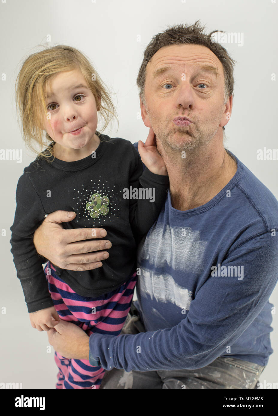 Dad and daughter making funny faces in studio Stock Photo - Alamy