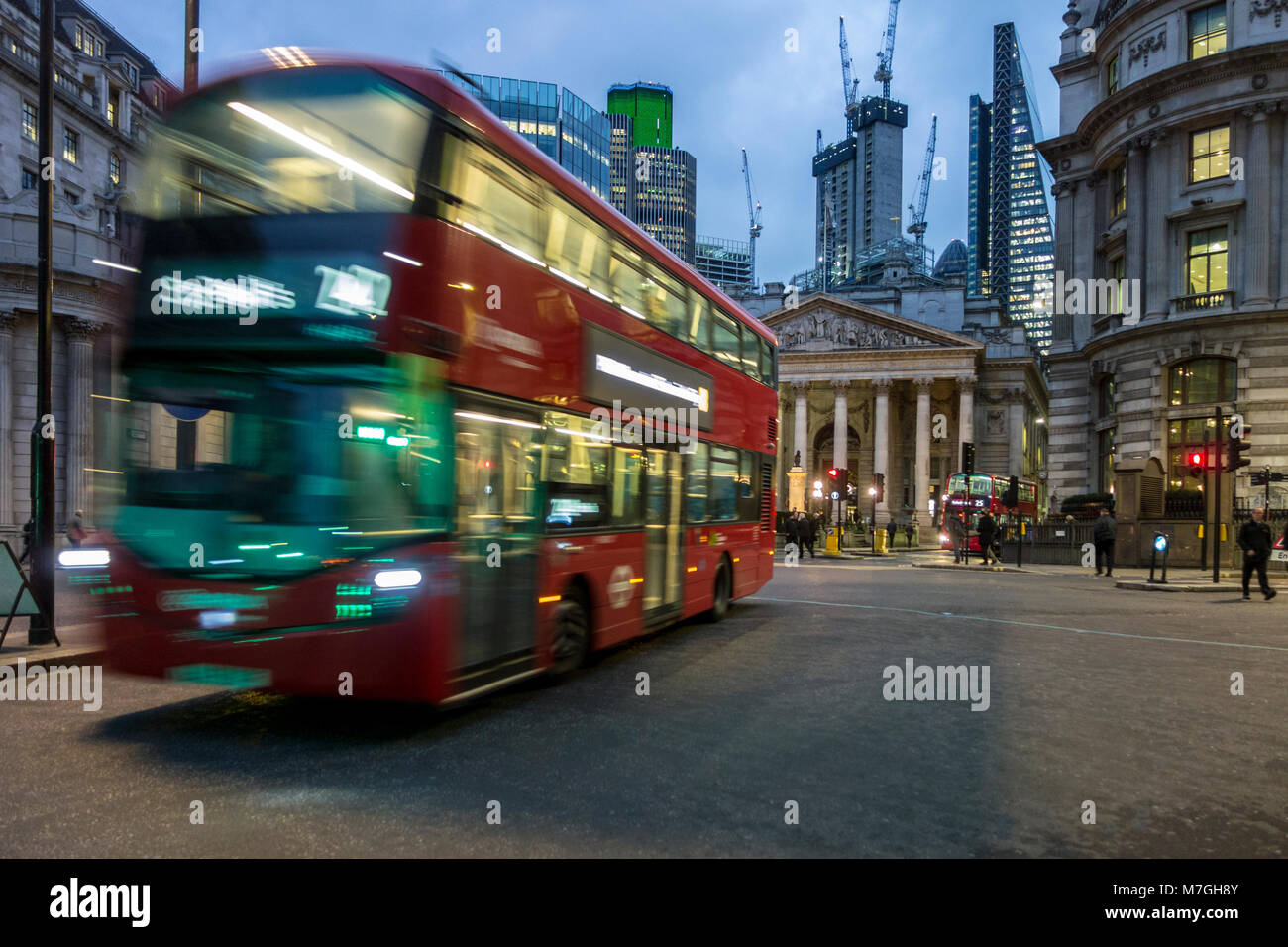 Red London bus on Bank junction at night with green traffic light ...