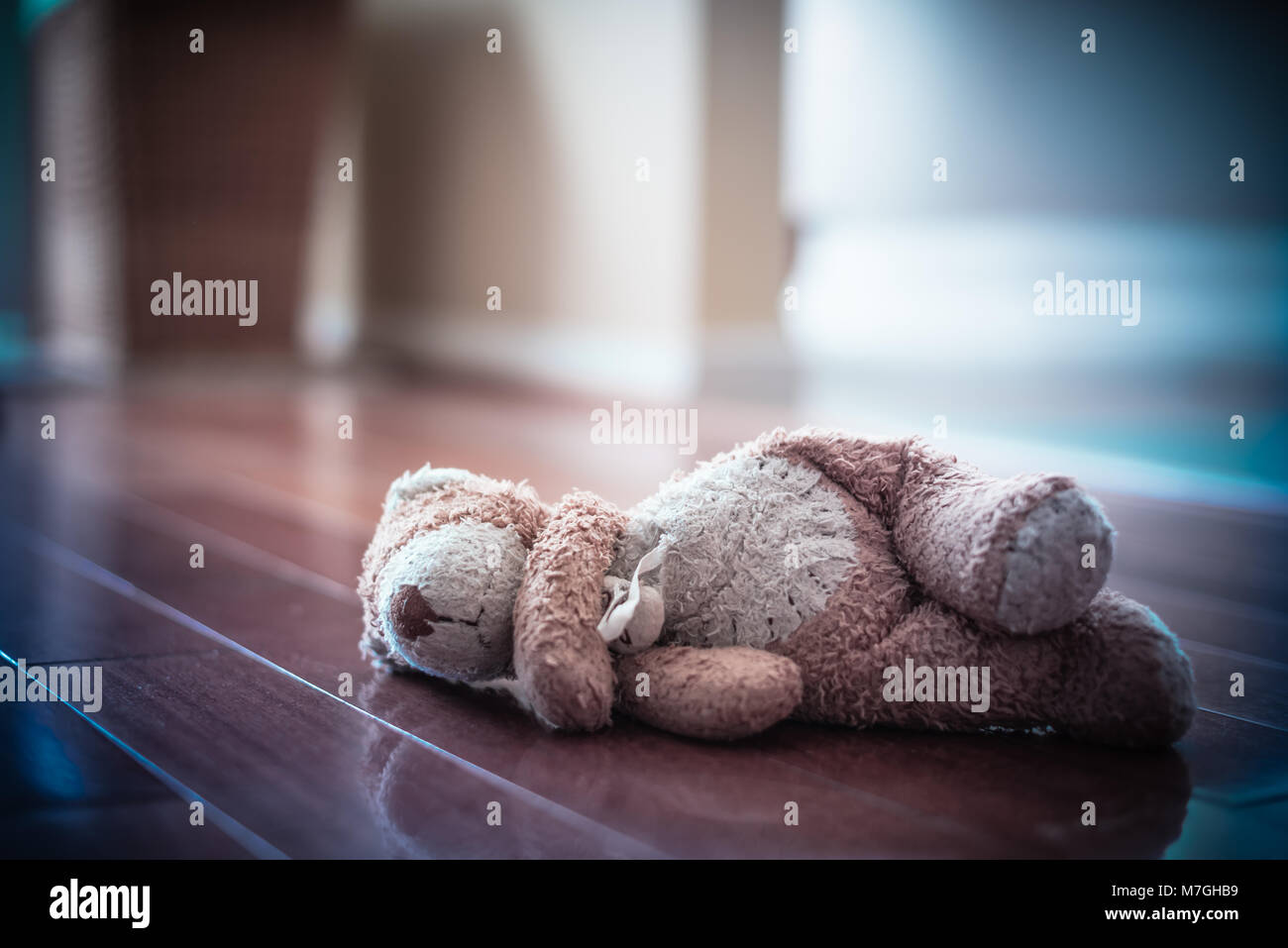 Forlorn old worn teddy bear left in empty room Stock Photo - Alamy