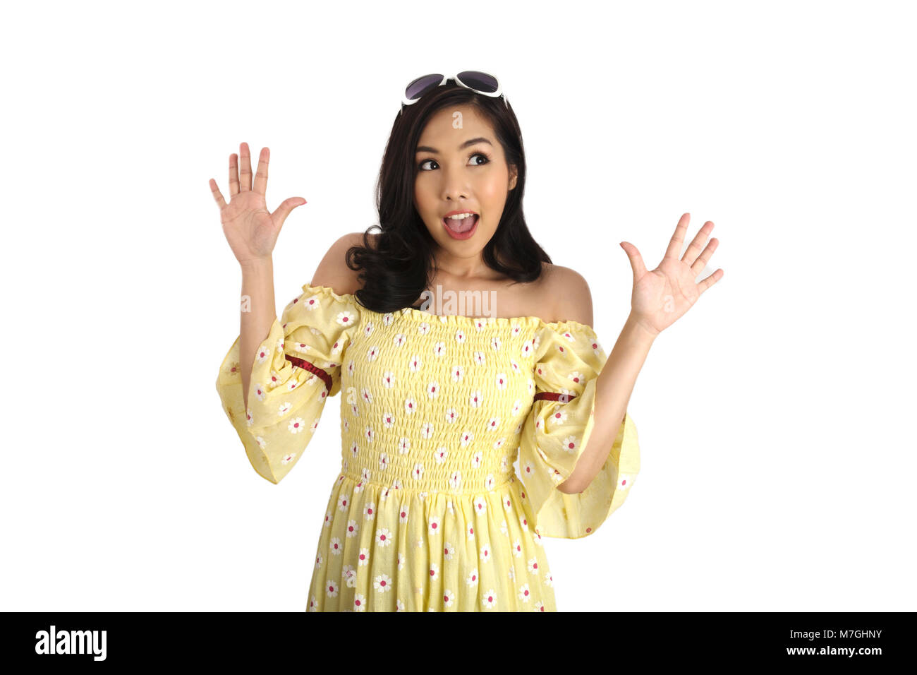 Asian girl in yellow floral dress with sunglasses on her head action ...