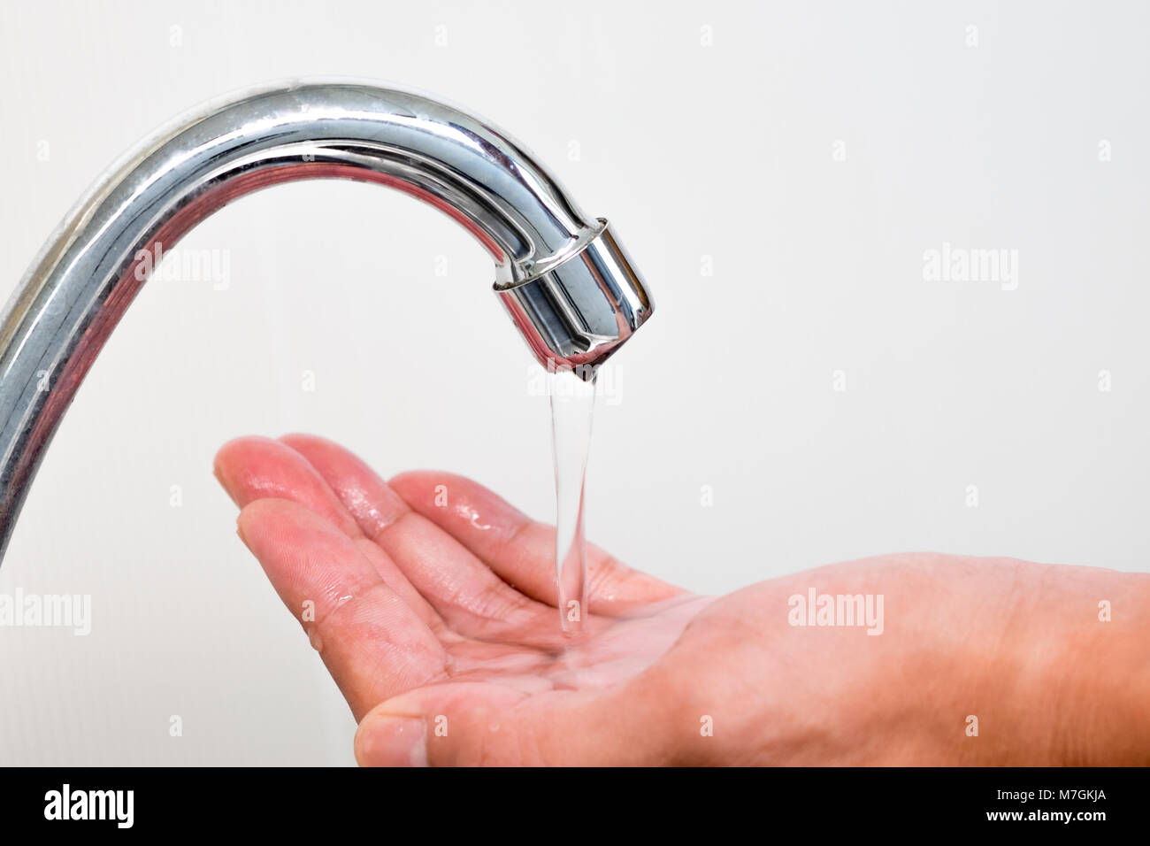 Water pouring from faucet to a hand. saving water Stock Photo - Alamy