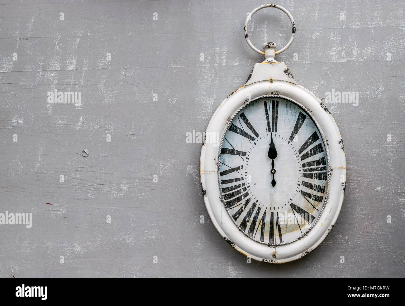 Old clock with roman numbers on a gray wall Stock Photo - Alamy