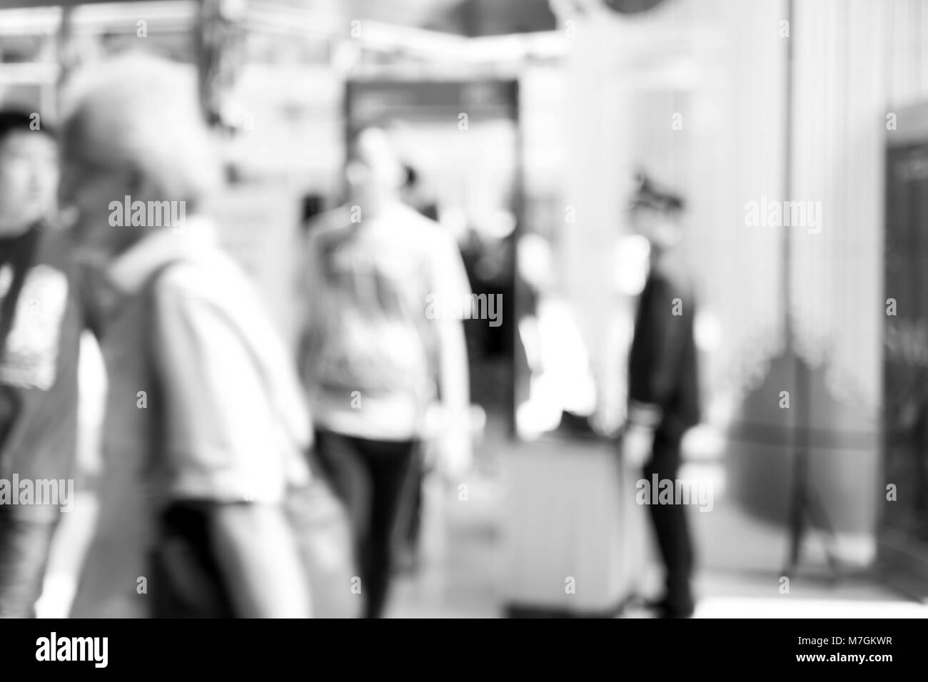 Abstract blur security guard watching people walking through the door ...
