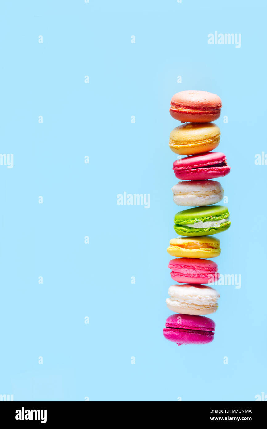 Assorted macaroons cookies tower with copy space on blue background ...