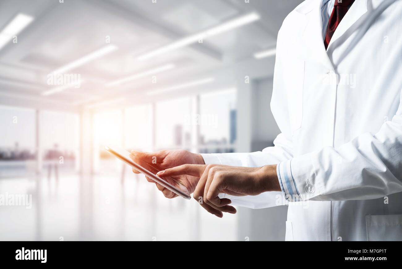 Cropped image of confident doctor in white sterile coat standing inside ...