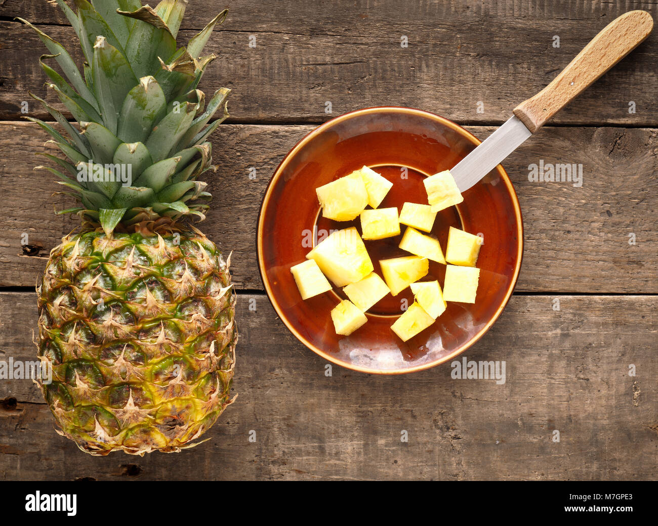 Sweet organic pineapple on a rustic wooden table Stock Photo - Alamy