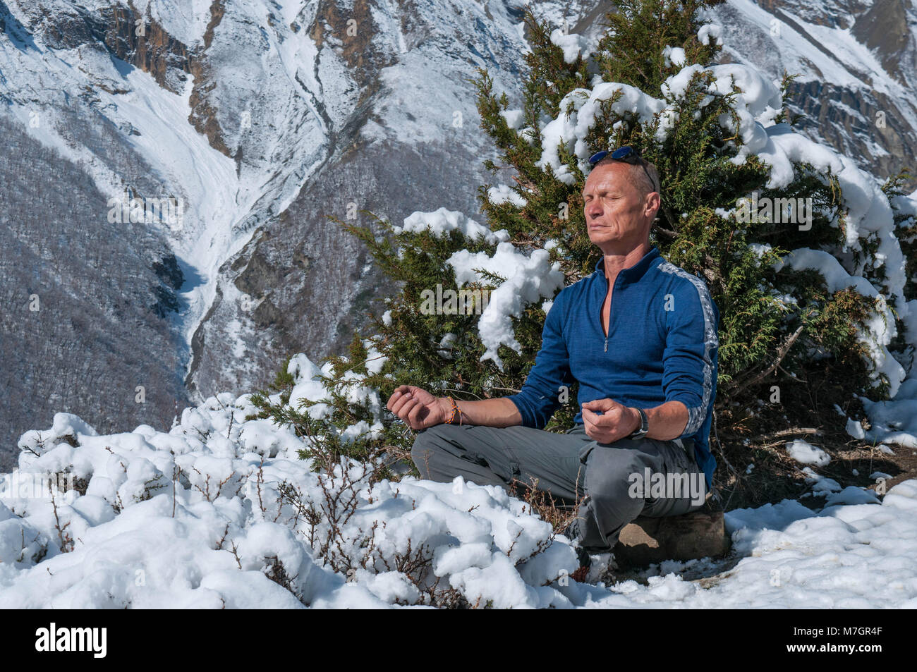 Meditating man in snowy Himalayan mountains Stock Photo - Alamy