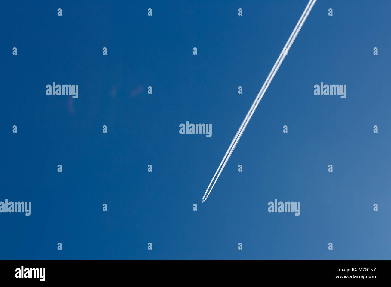 Trace of the flying jet plane in the clear winter sky Stock Photo - Alamy