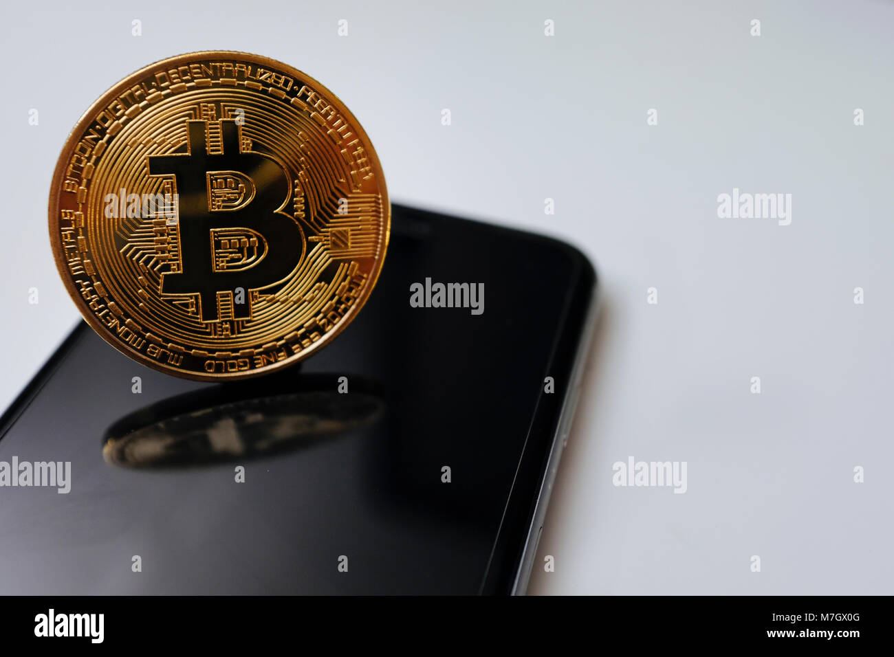 Bitcoin on clean background with smartphone Stock Photo - Alamy