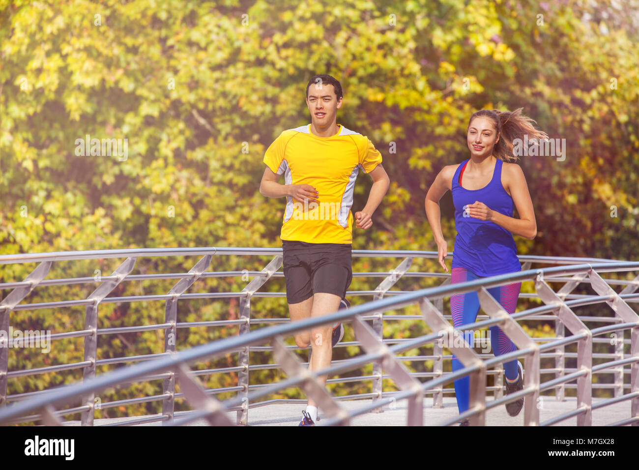Portrait of two young runners in perfect shape, man and woman in ...