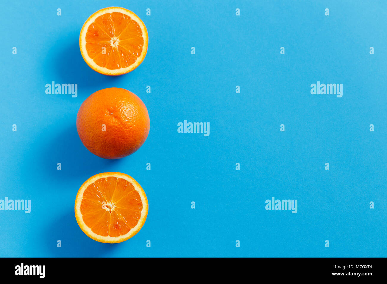 Oranges isolated on blue background Stock Photo - Alamy