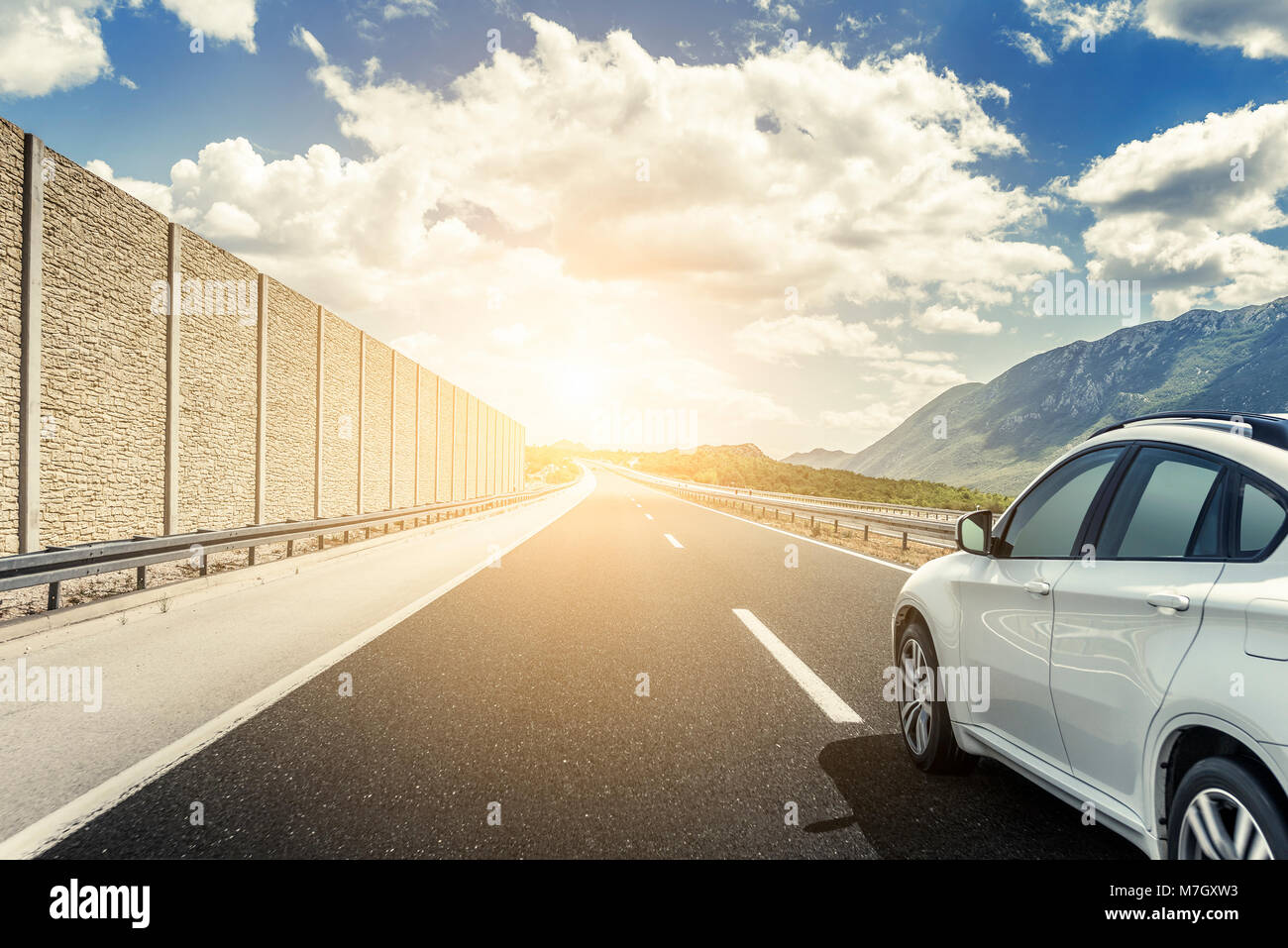 White car rushing along a high-speed highway. Toned photo Stock Photo ...