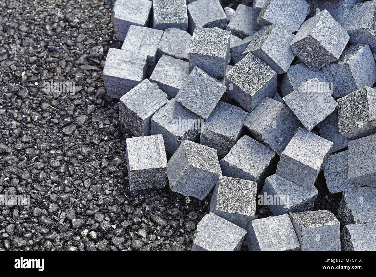 Big bunch of cobblestone bricks at new asphalt Stock Photo - Alamy