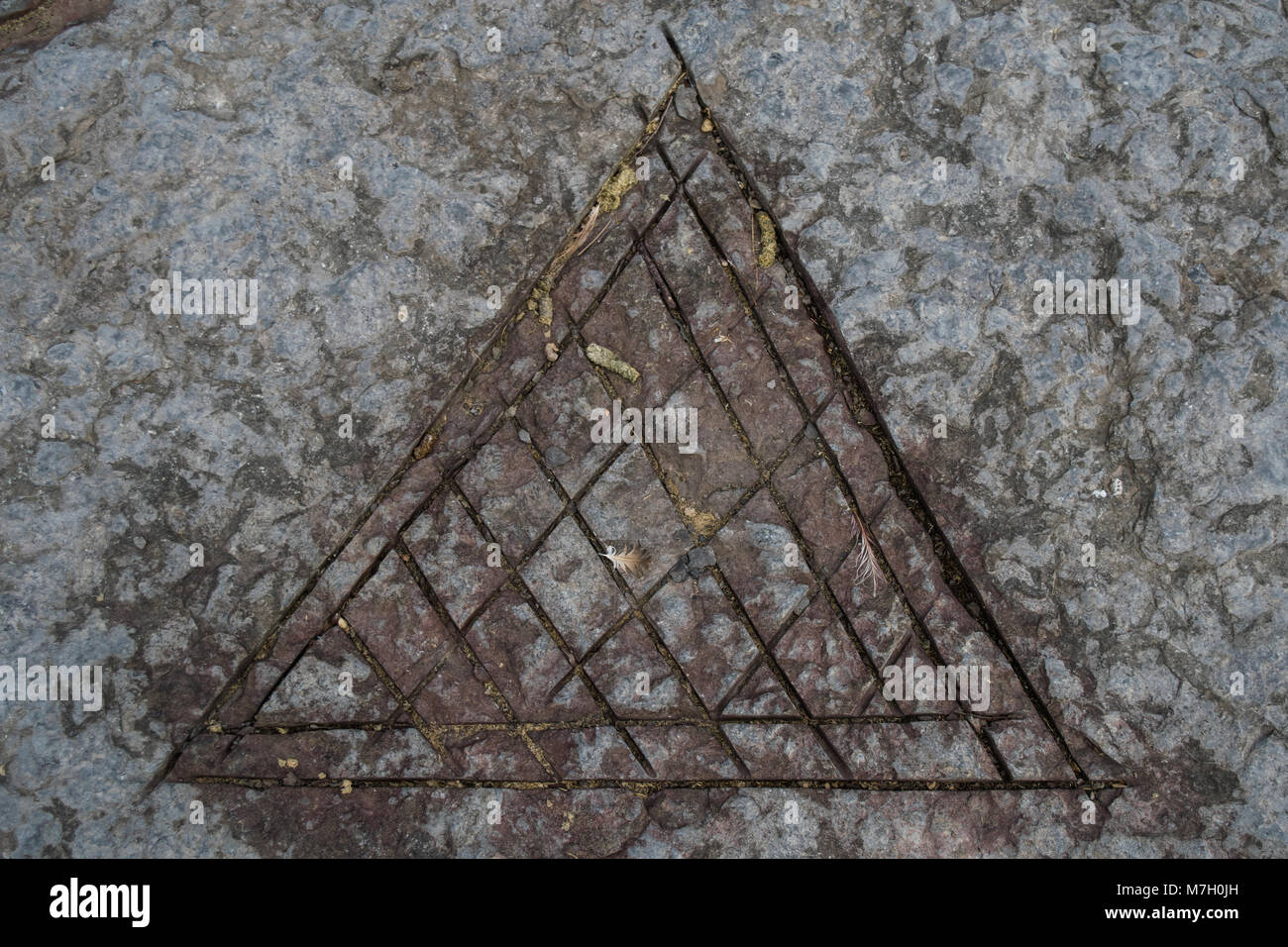 A triangle pattern carved into shale stone along the shore of the ...