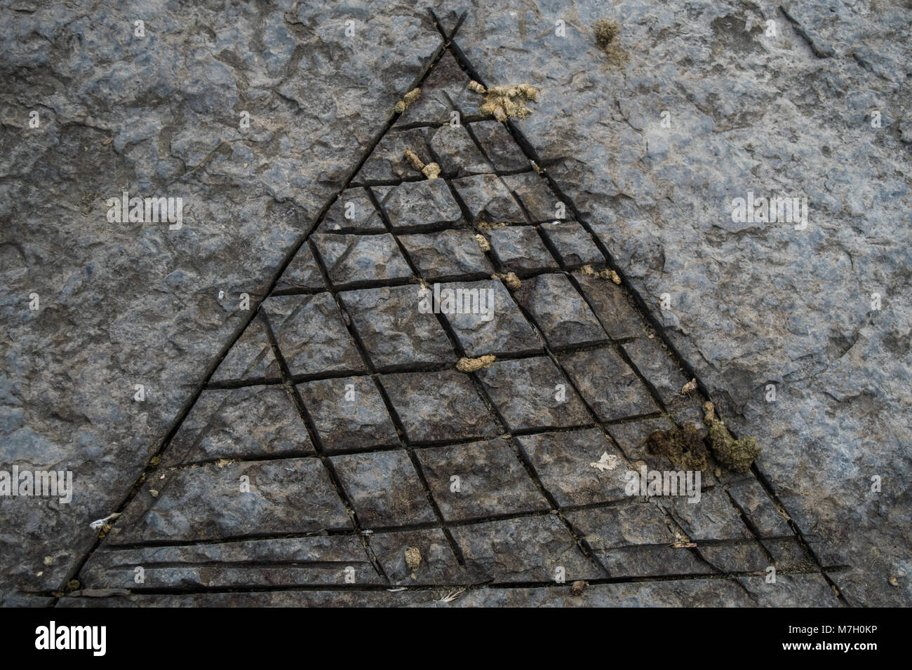 A triangle pattern carved into shale stone along the shore of the ...