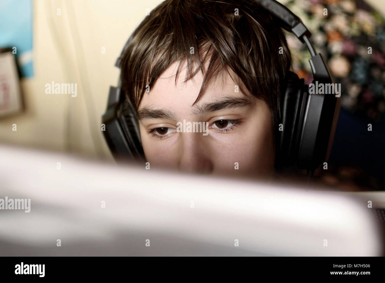 Close up of young boy staring at laptop screen during playing computer ...