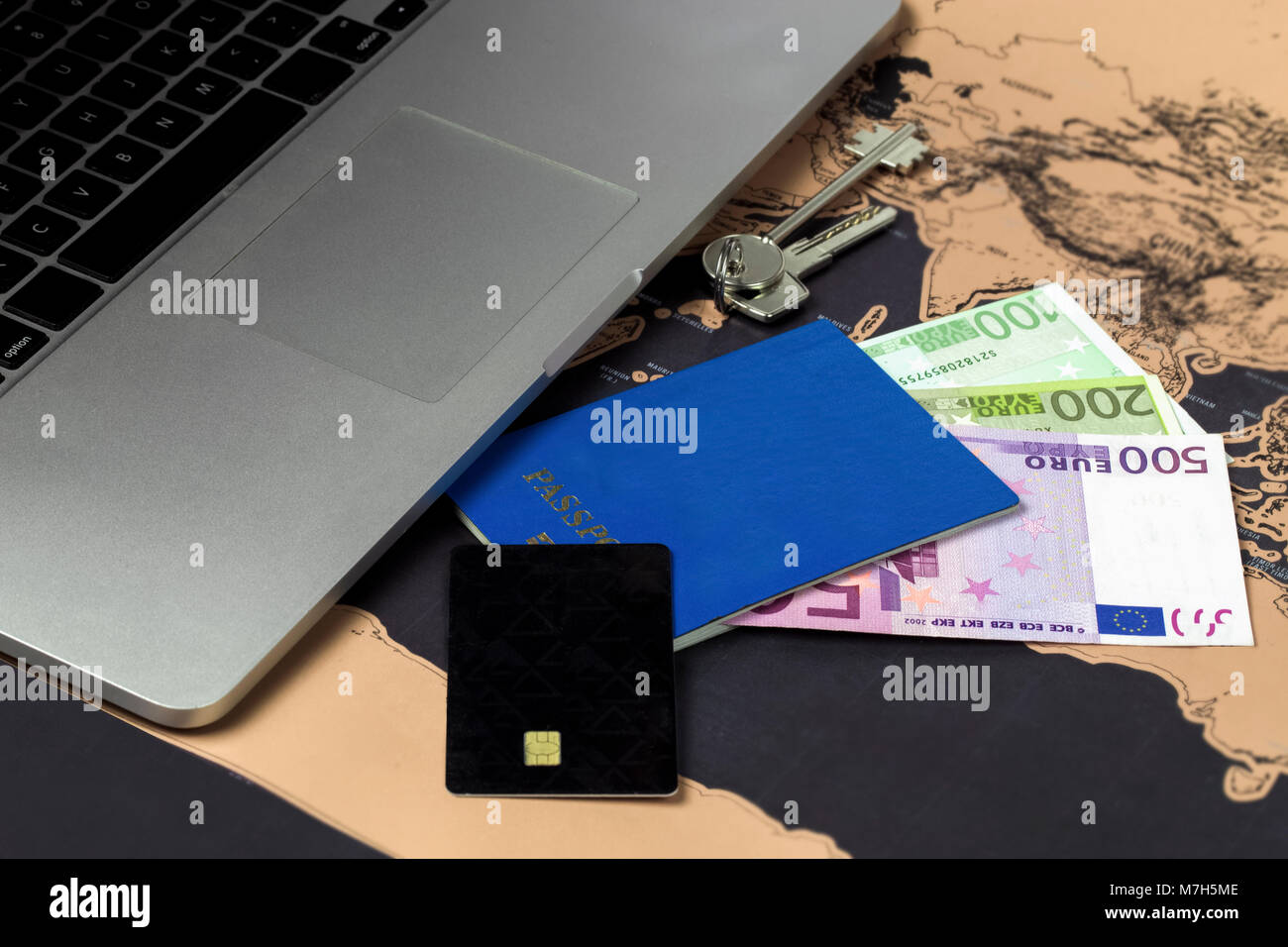 laptop bank card keys and money on a geographic map, background image ...