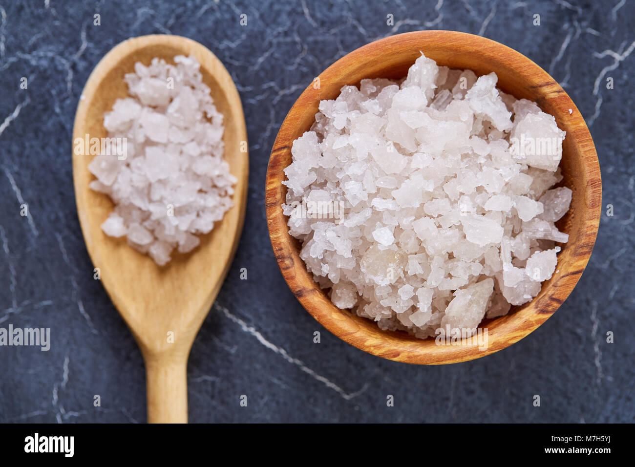 Large white sea salt crystals in a natural wooden bowl and wooden spoon ...