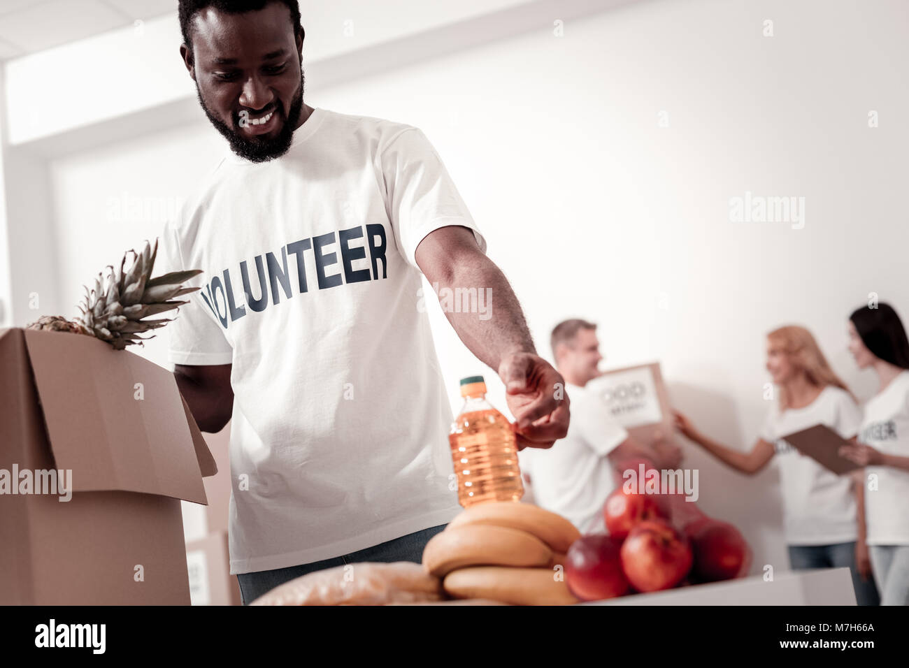 Delighted dark-skinned man collecting products Stock Photo - Alamy