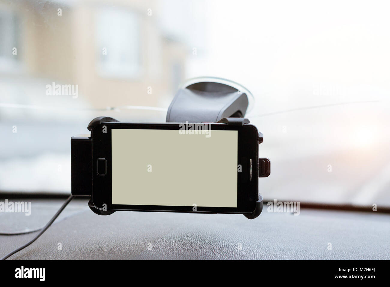 Car smartphone holder with phone attached to the windscreen of ...