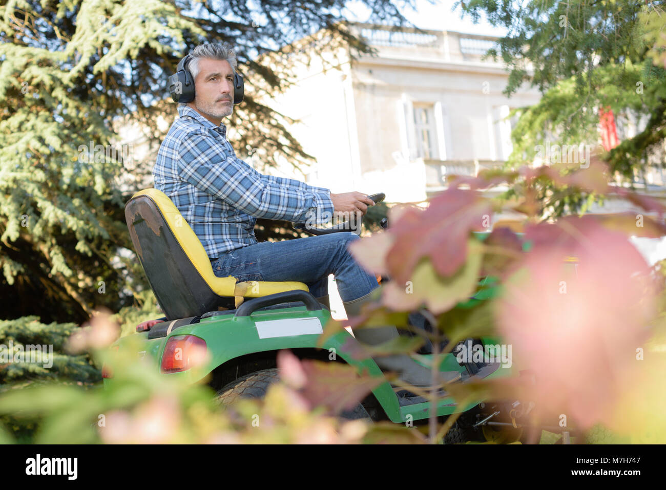 Man on ride on mower Stock Photo - Alamy