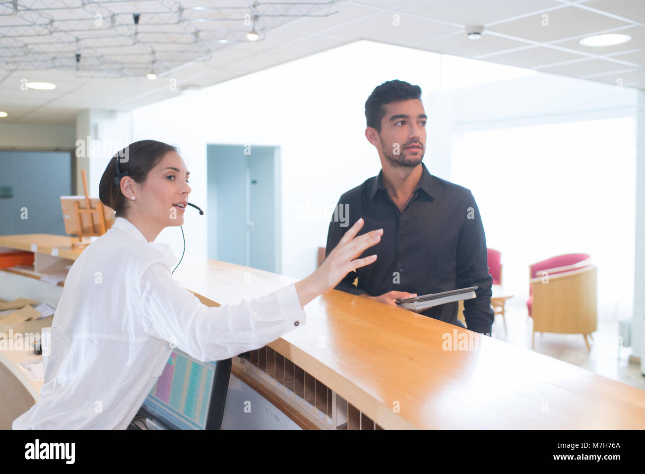 woman behind the reception desk administrator with customer visitor ...