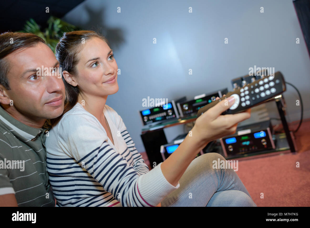 Man and woman surrounded by technology, holding remote control Stock ...