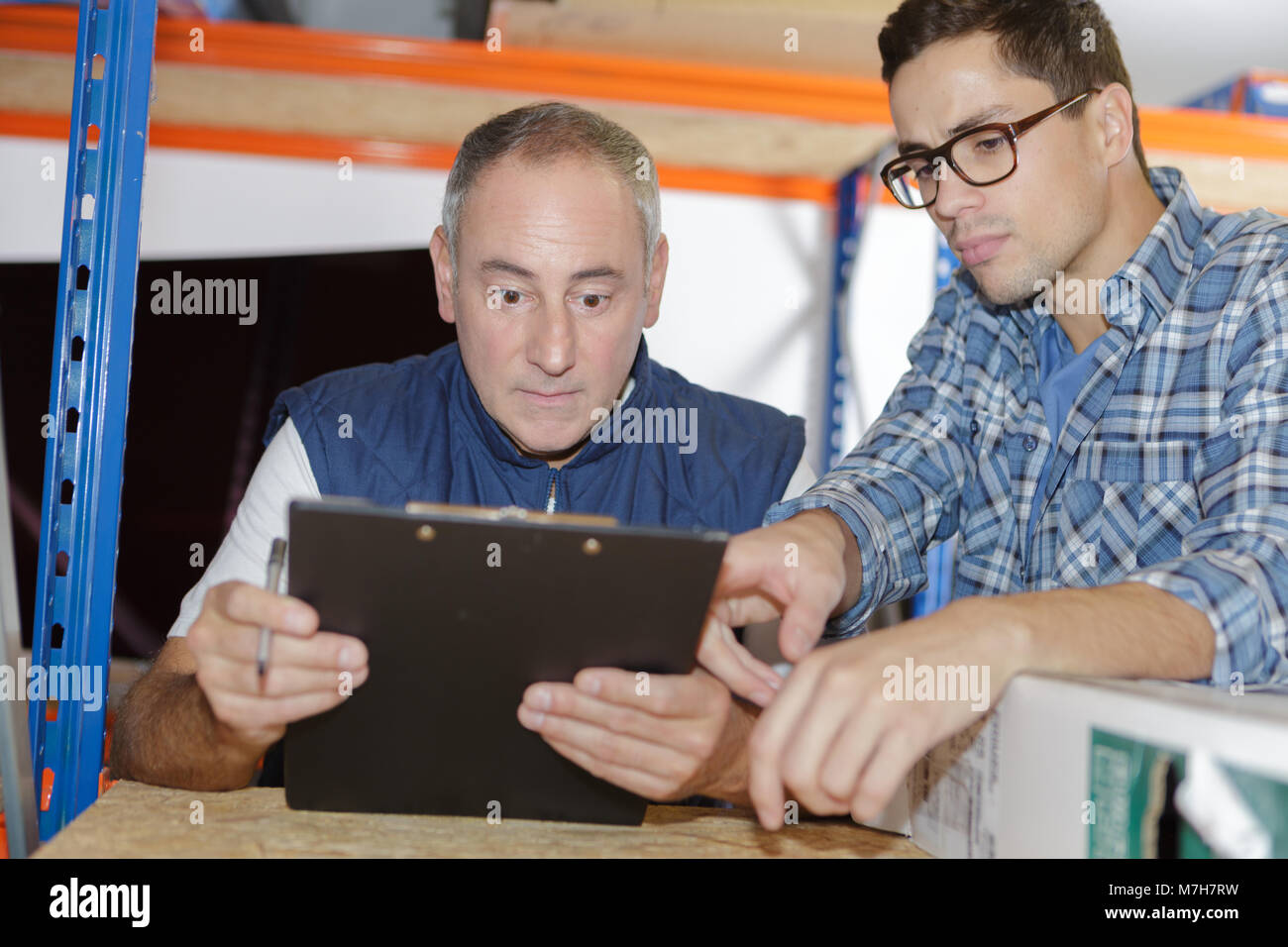 two men checking supply stock in the warehouse Stock Photo - Alamy