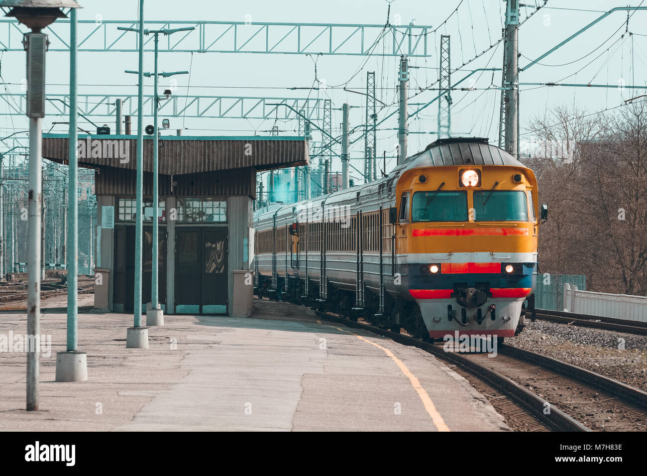 Old yellow passenger diesel train moving at the terminal Stock Photo ...
