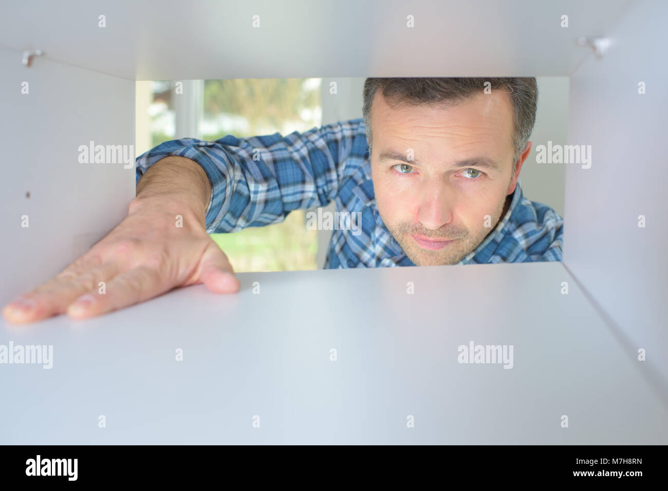 happy young man looking inside box Stock Photo - Alamy