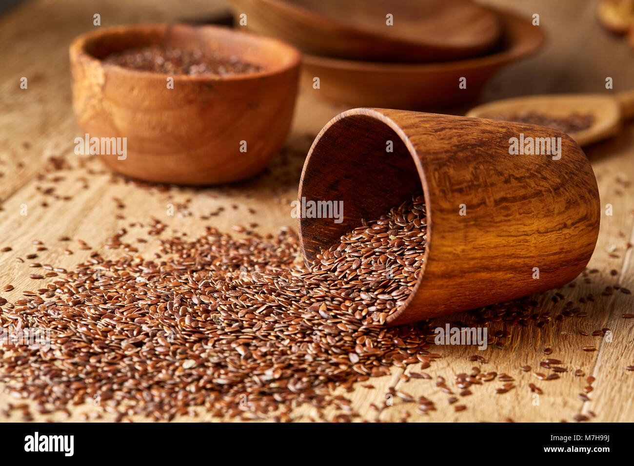 An overturned wooden bowl with linseeds on a rustic background, close ...
