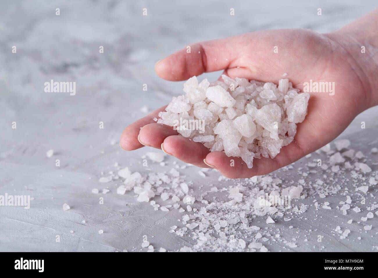 Sea salt crystals in women hand on white background, top view, close-up ...