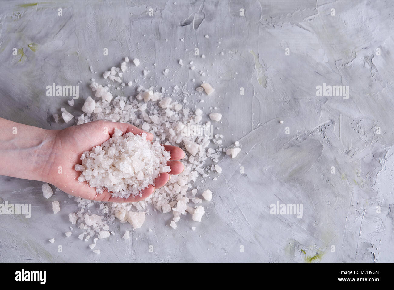 Sea salt crystals in women hand on white background, top view, close-up ...