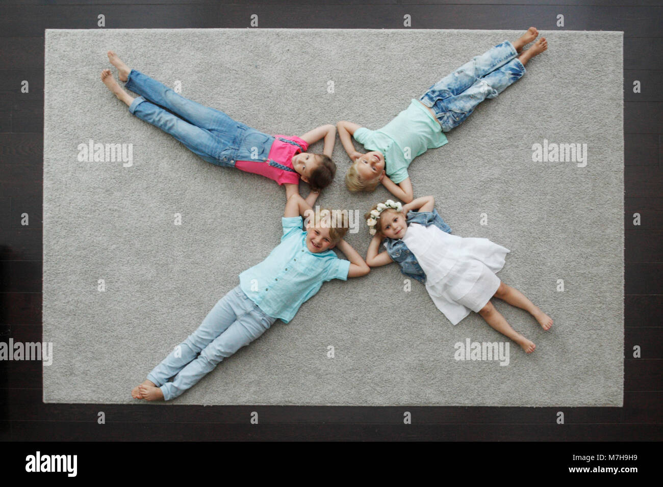 Group of happy kids laying on floor, top view Stock Photo - Alamy