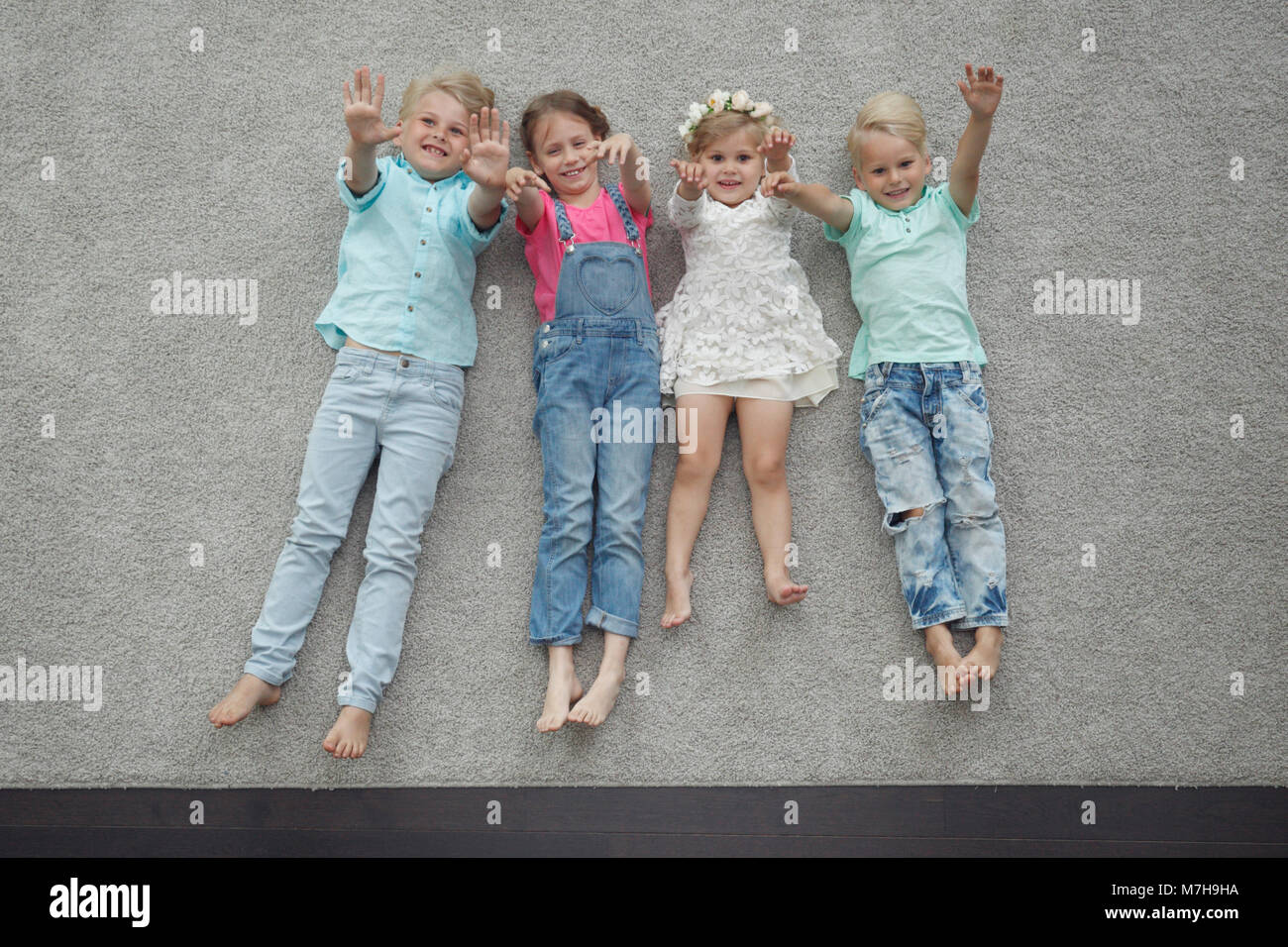 Group of happy kids laying on floor, top view Stock Photo - Alamy