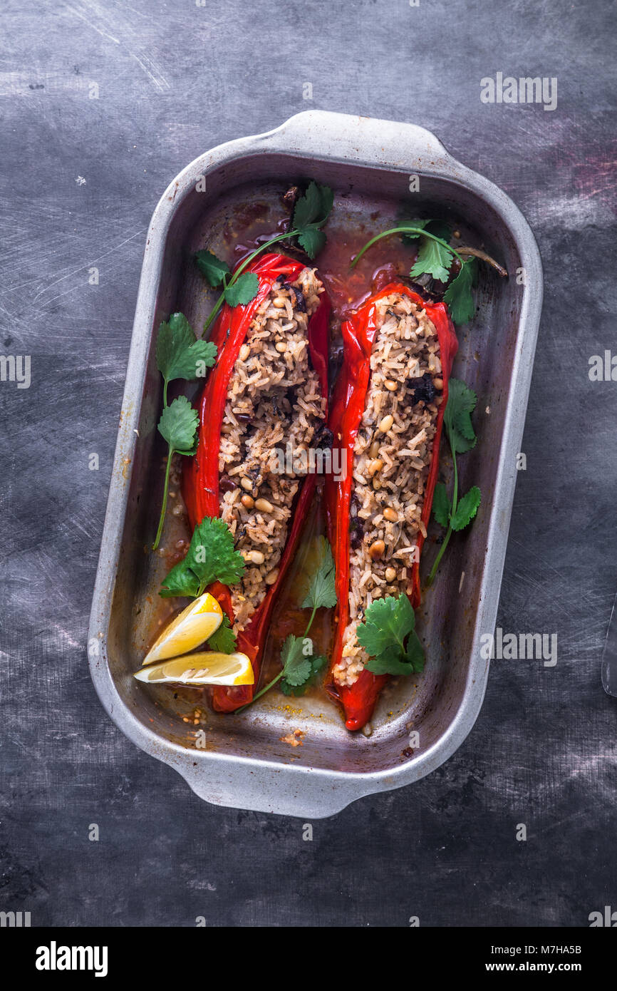 Stuffed paprika peppers in iron cooking pot on dark rustic kitchen ...