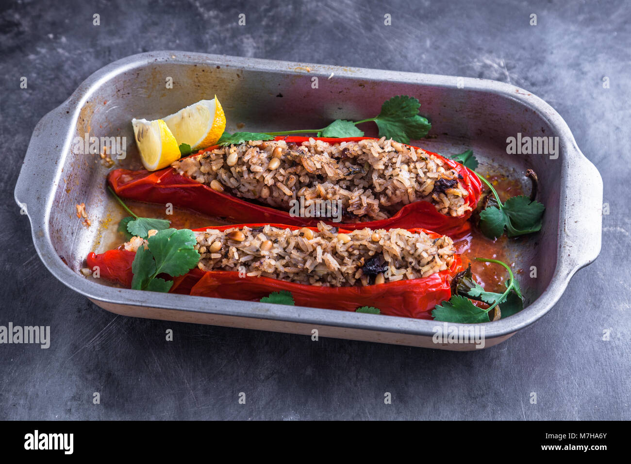 Stuffed paprika peppers in iron cooking pot on dark rustic kitchen ...