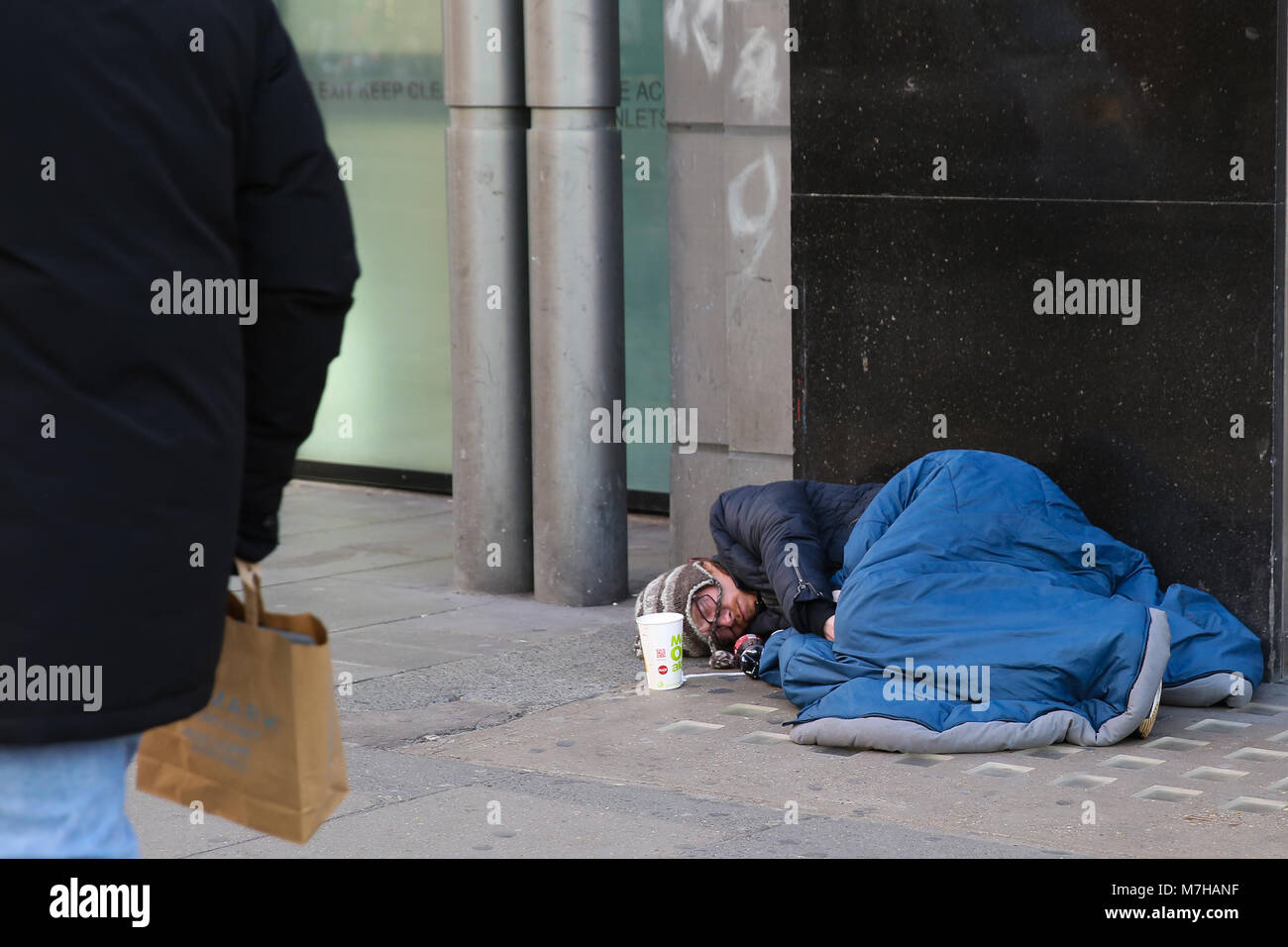 A homeless person sleeping in a sleeping bag in Oxford Street ...