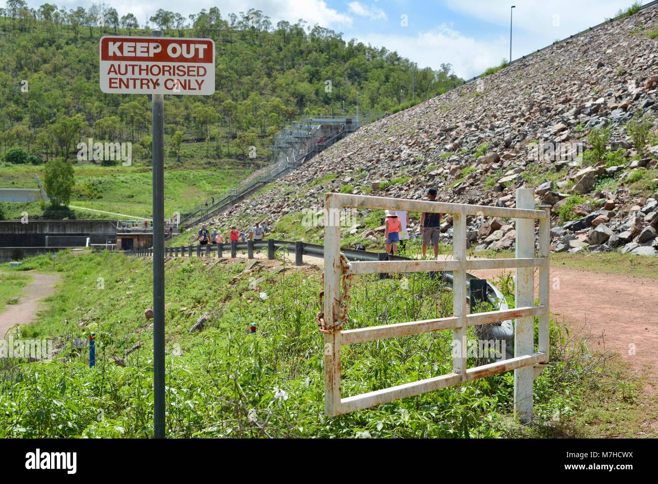 People walking past a Keep out authorised entry only sign, Ross River ...