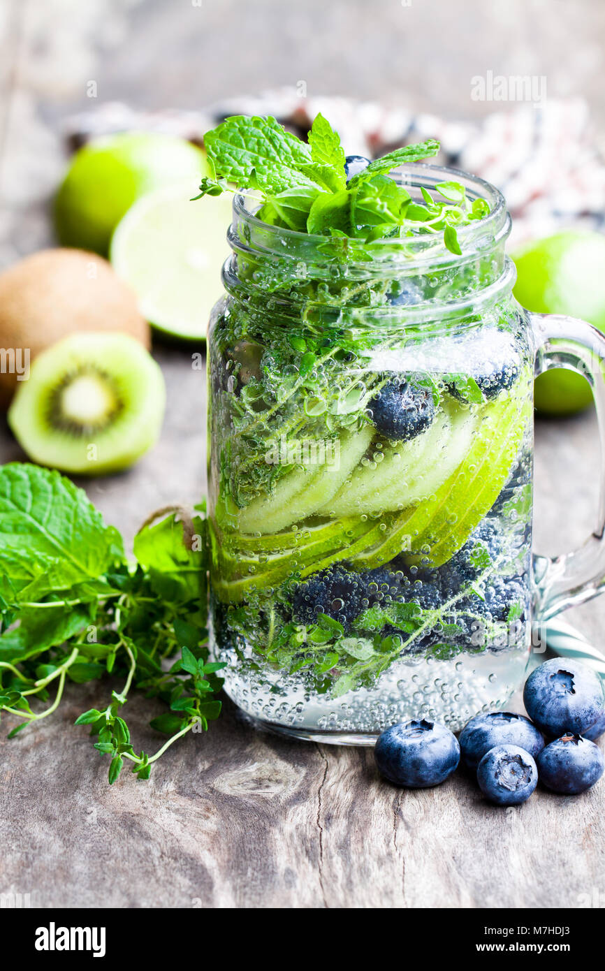 Detox water. Homemade summer fruit drink with lime and kiwi and ...